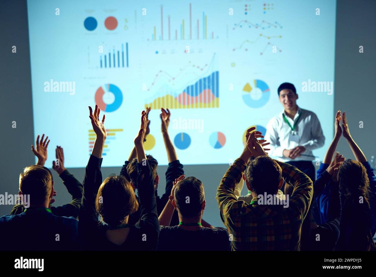 Corporate training session surrounded by data visualizations where man ...