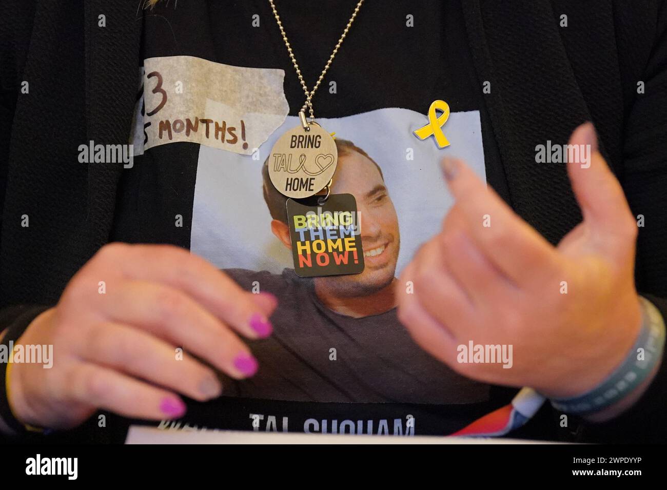 Inbal Zach, cousin of Tal Shoham, displays his picture on her clothing ...