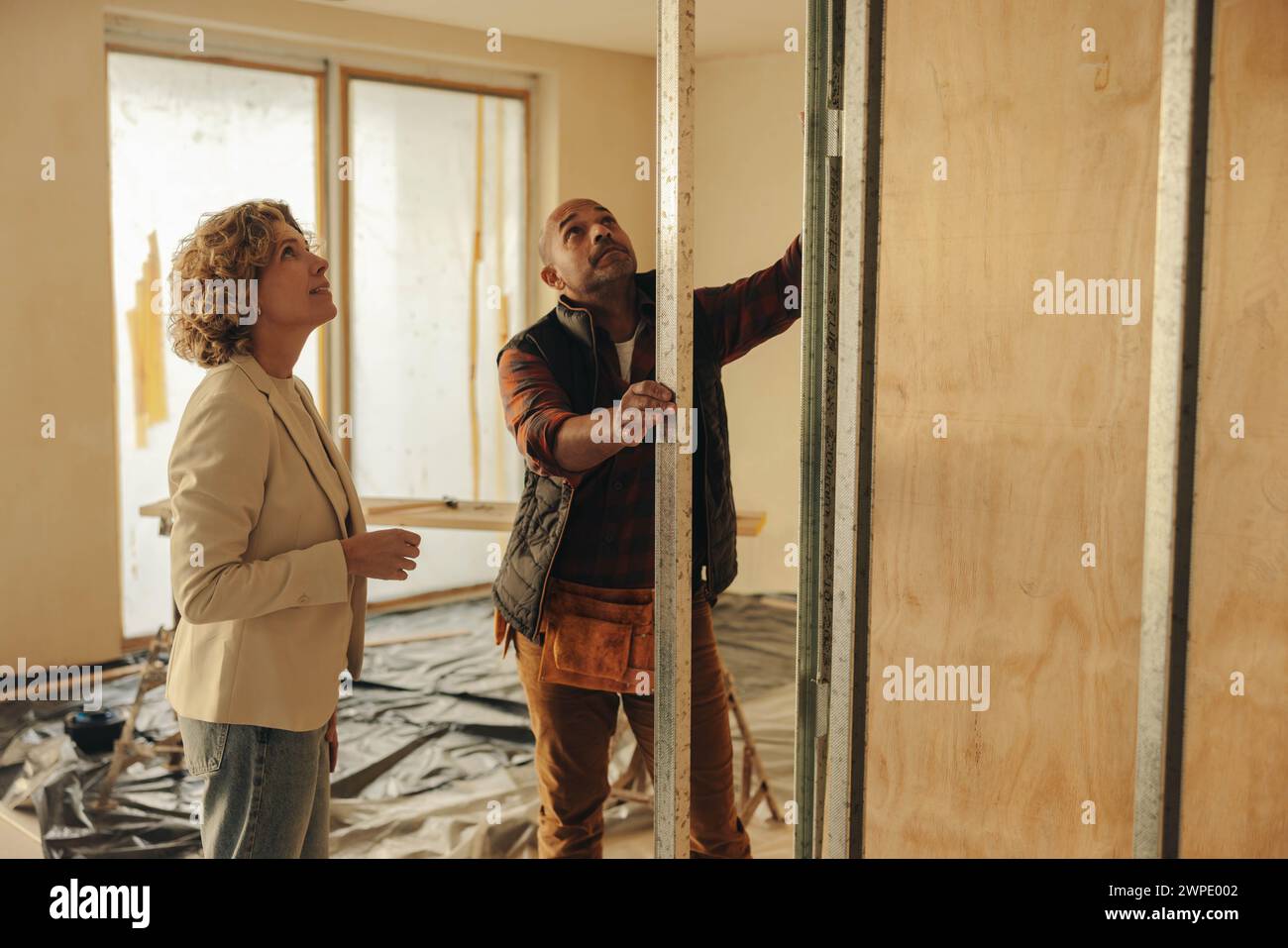 Construction worker and house architect discussing interior remodeling ...
