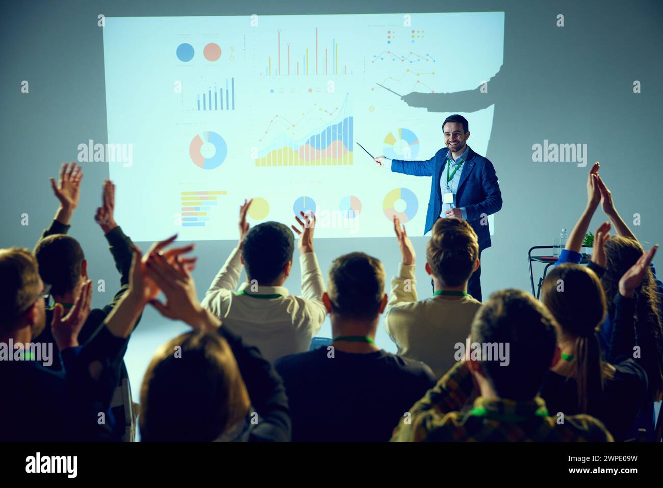 Corporate training lecture surrounded by data visualizations where man ...