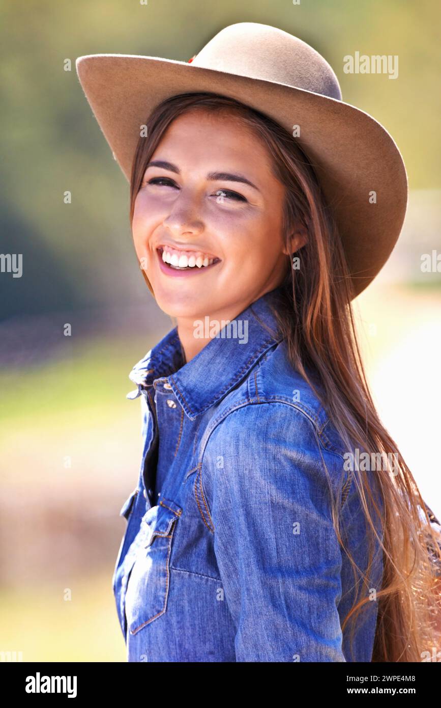 Happy woman, portrait and cowgirl with hat on farmland for adventure ...