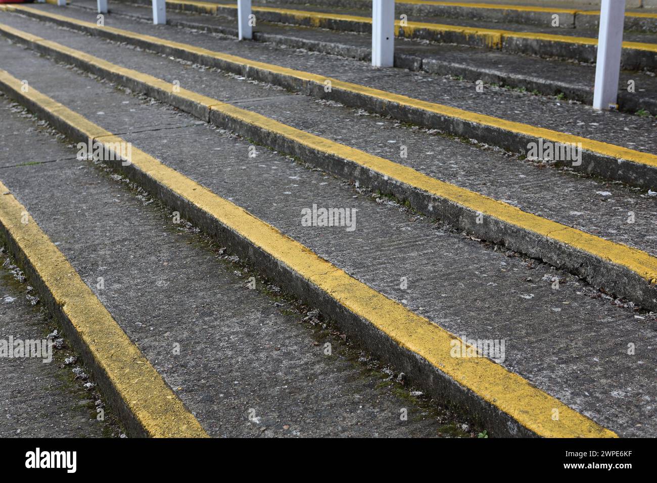 Terracing concrete steps with yellow painted lines on edges, and metal ...
