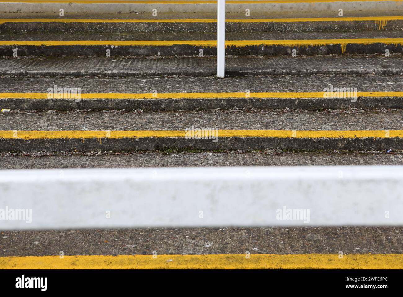 Terracing concrete steps with yellow painted lines on edges, and metal ...