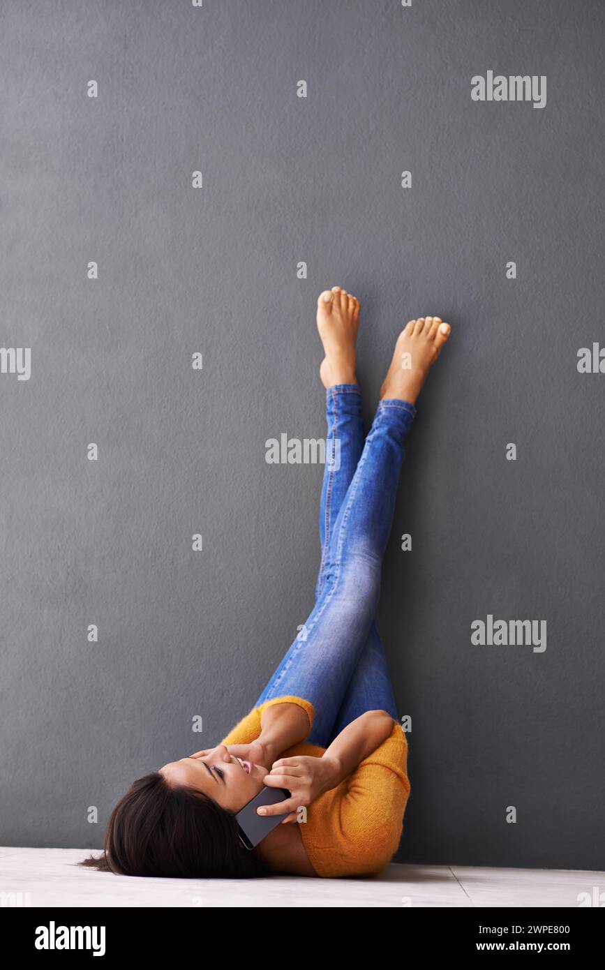 Feet up, phone call or woman relax on a floor with mockup for chat ...