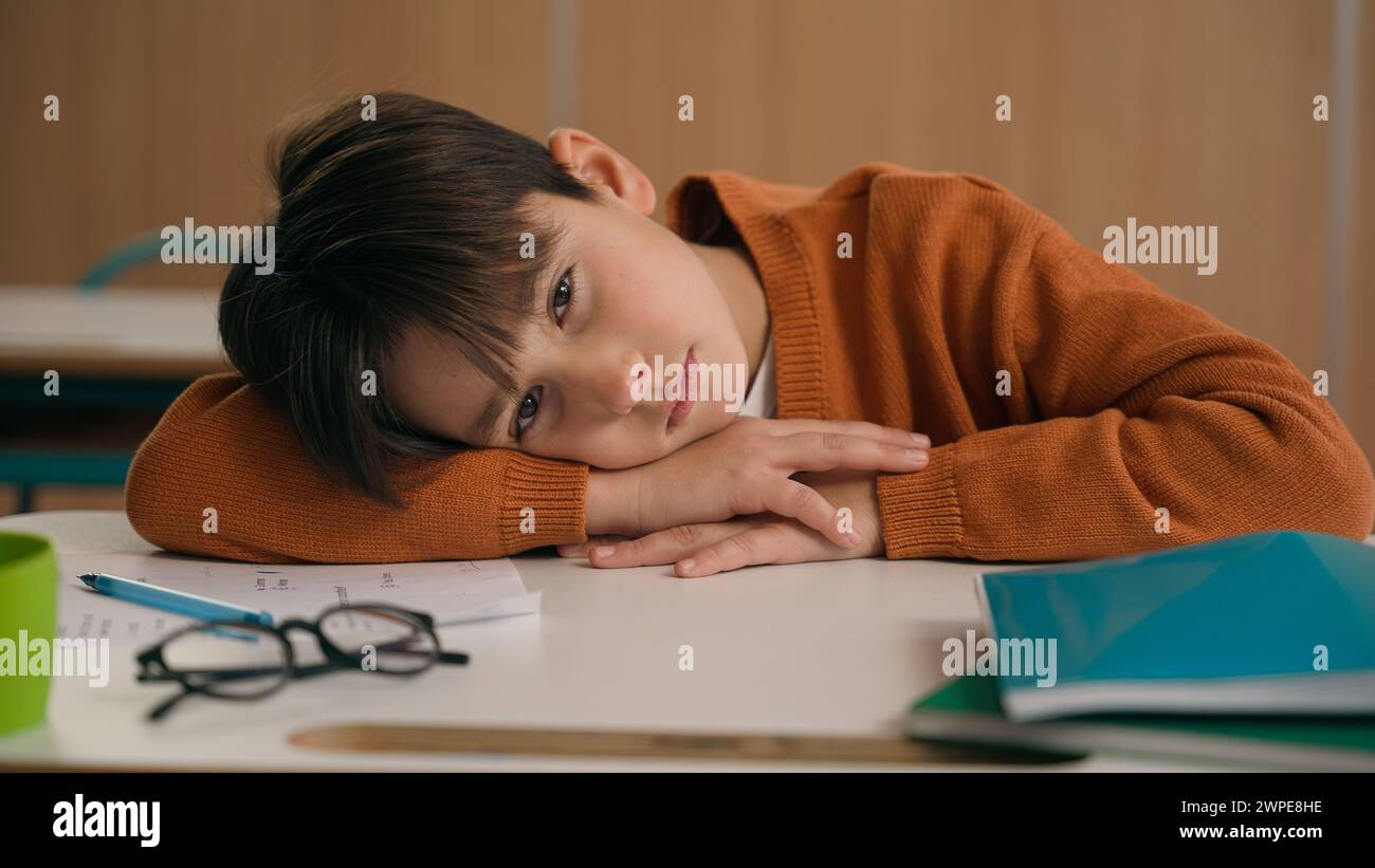 Caucasian bored schoolboy sleepy at school elementary education study ...