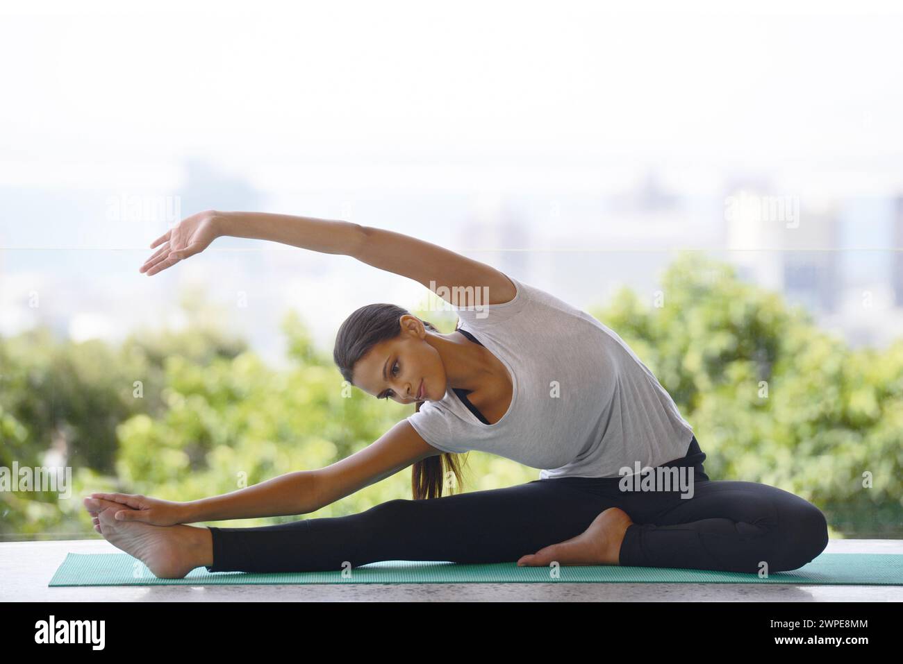 Woman, yoga and stretching with mat by window for workout, exercise or ...