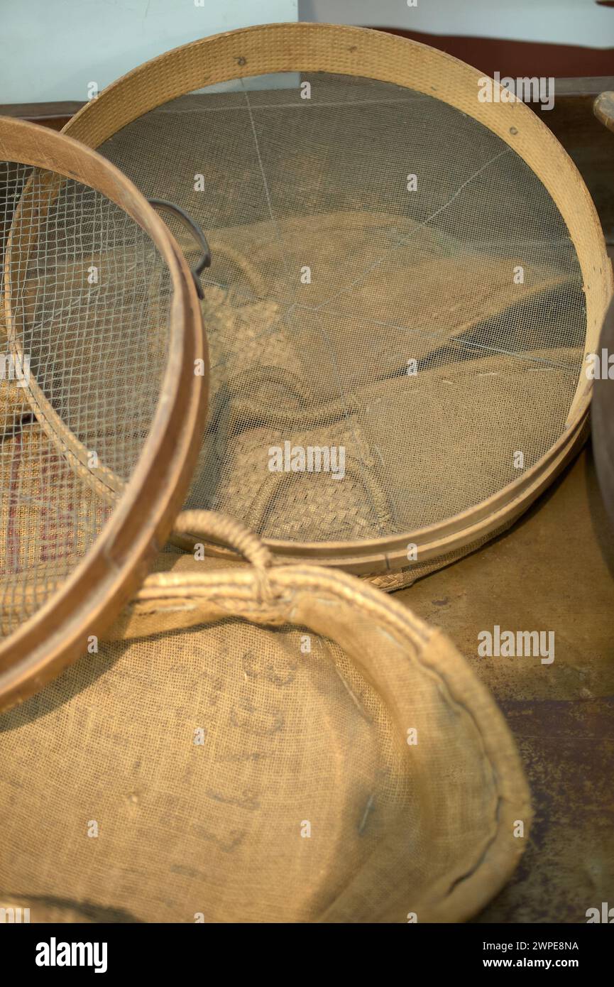 Wooden and metal mesh sieves resting on a sackcloth surface and a ...