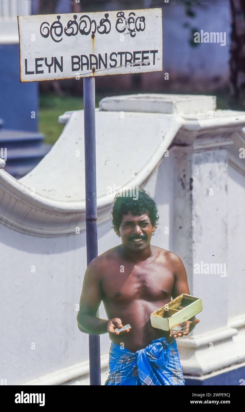 Sri Lanka, Galle; man shows old Dutch VOC coins in front of a colonial ...