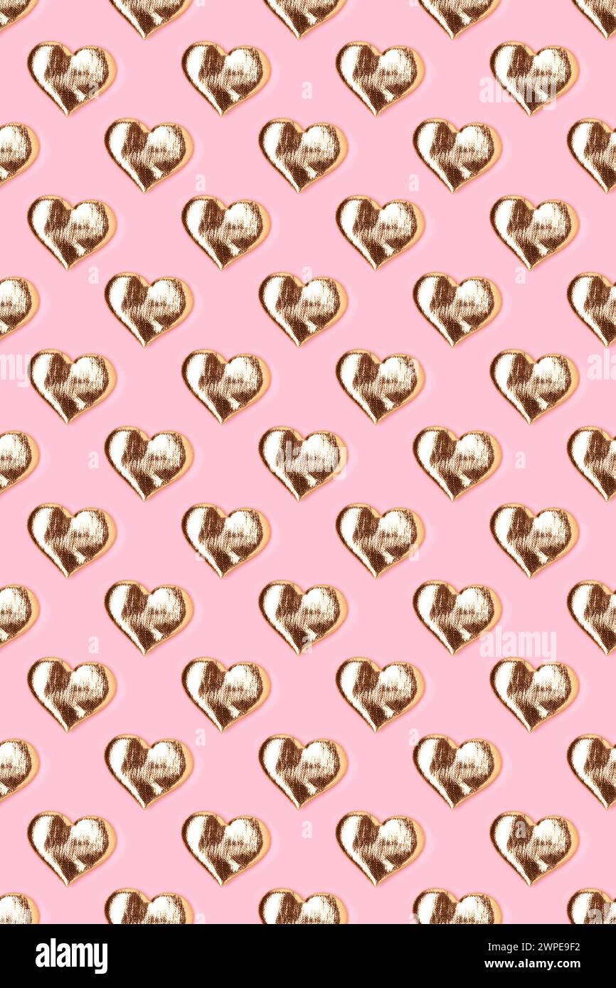 Repetitive pattern made of gold colored hearts. Creative layout on a ...