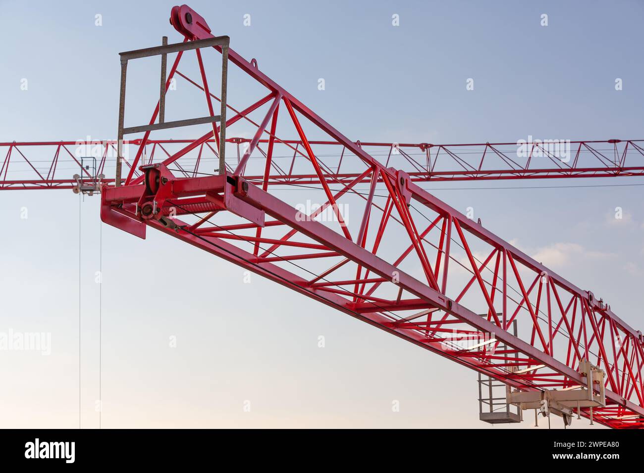 The booms of two red construction cranes cross each other Stock Photo ...