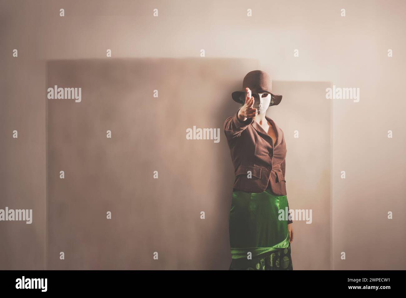 circus woman with mask plays a tragic comic scene pointing a fake gun ...
