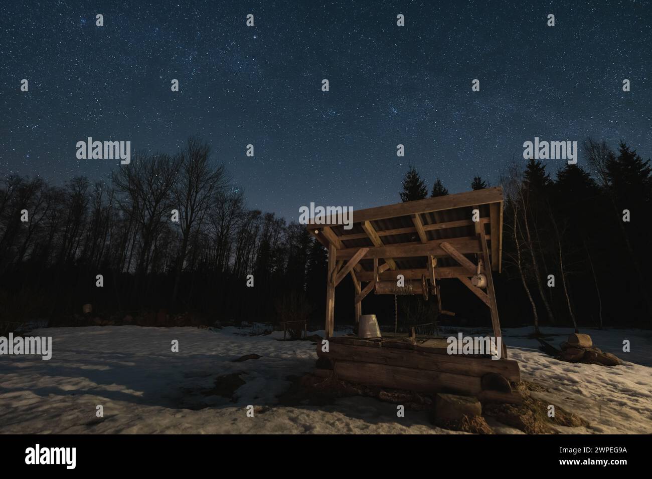 Night scene, landscape astrophoto, old well in the forest with a starry ...