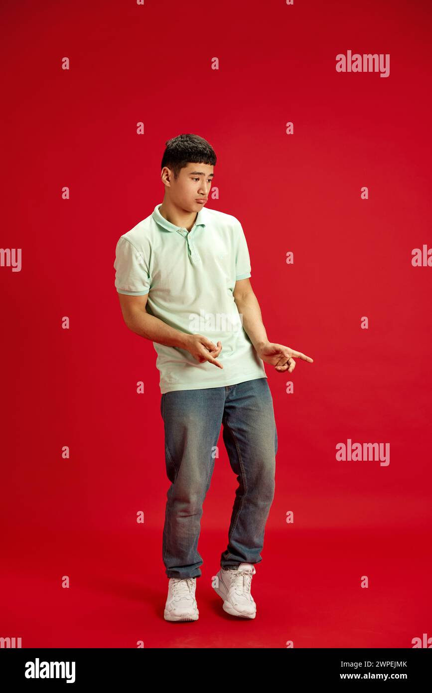 Full length of excited funny young Asian man 20s in basic casual outfit ...