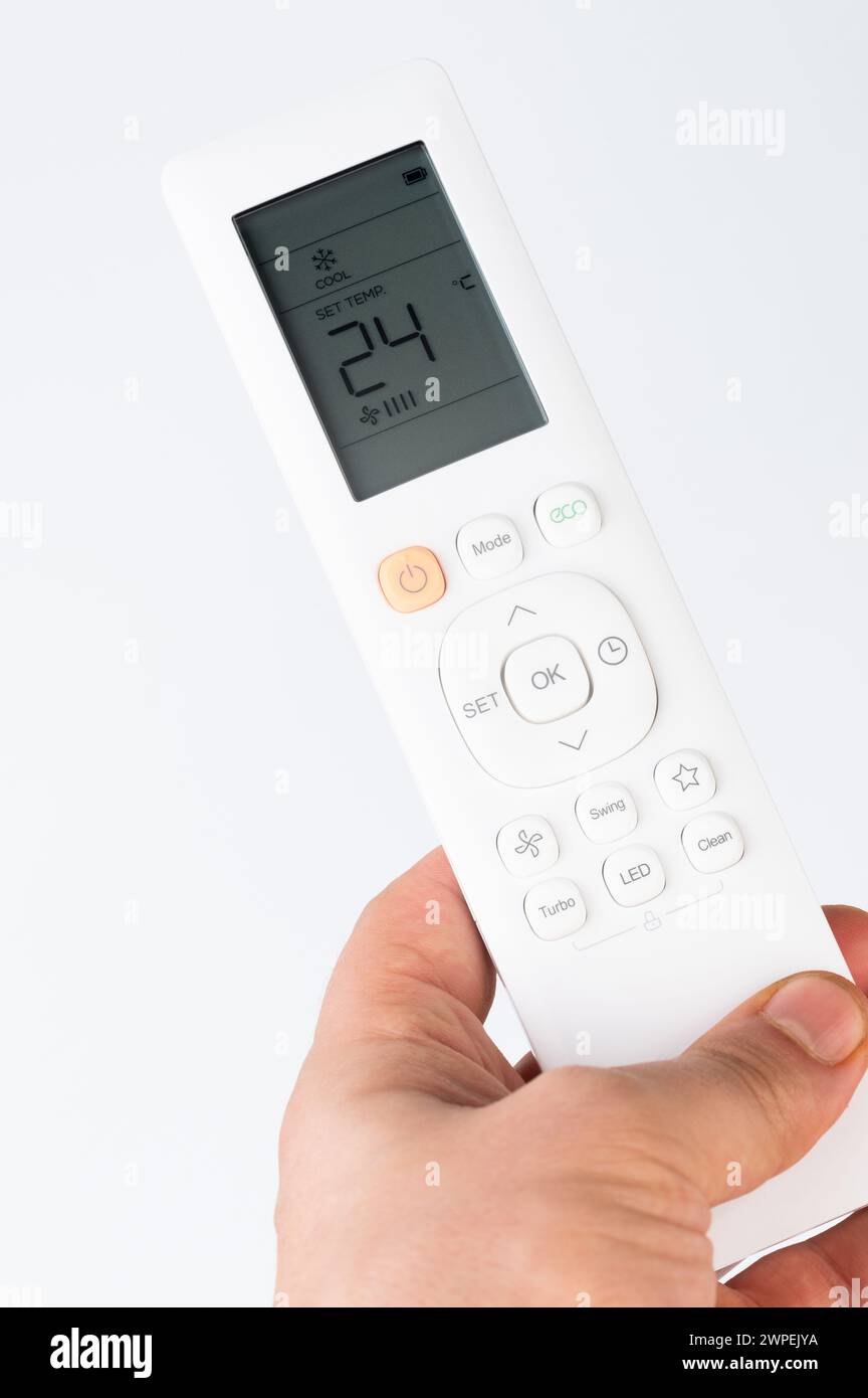 White air conditioner remote control in hand isolated on studio ...