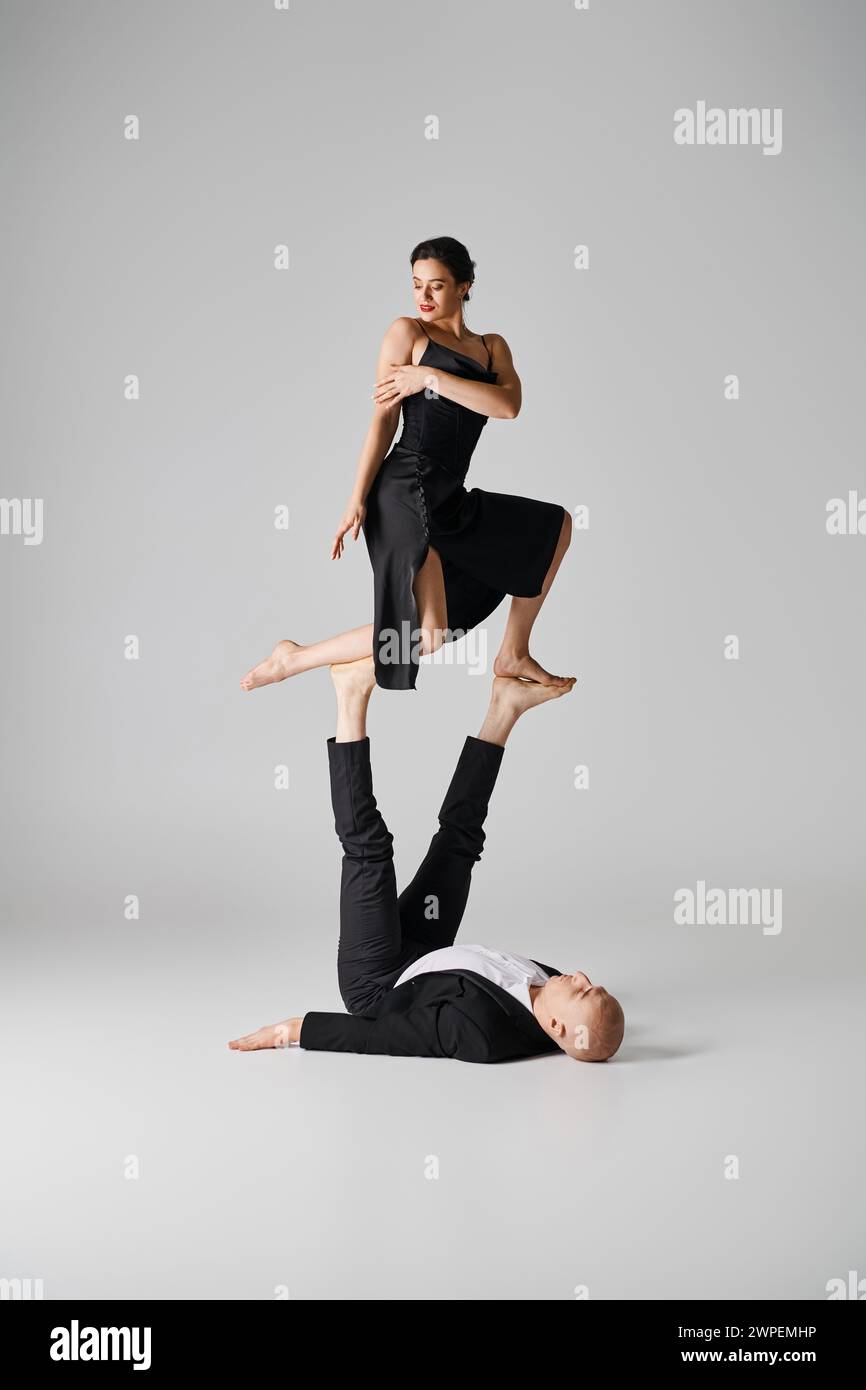 Dynamic duo of two acrobats performing balance act in a studio setting ...