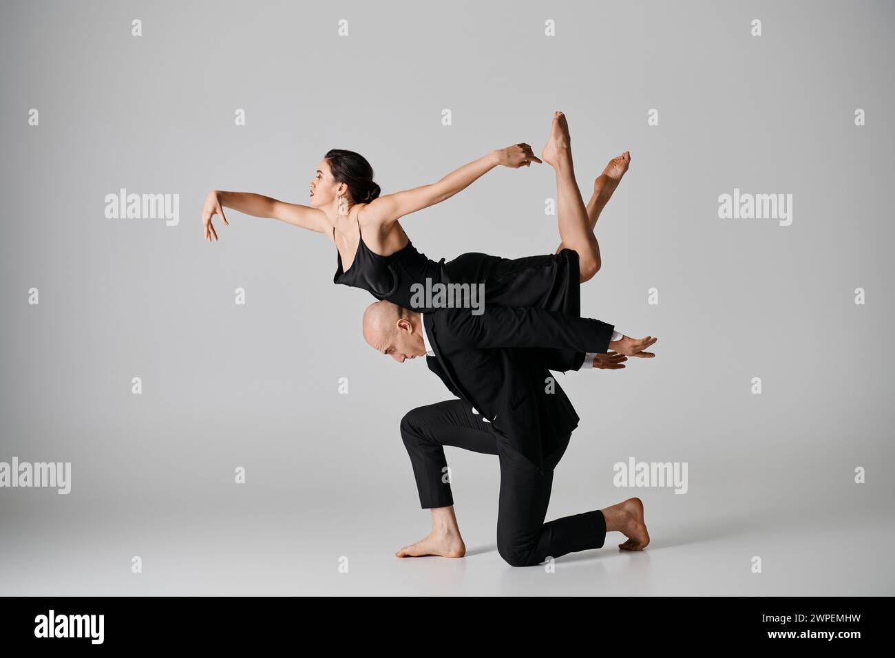 Graceful dance, young couple performing an acrobatic routine in studio ...