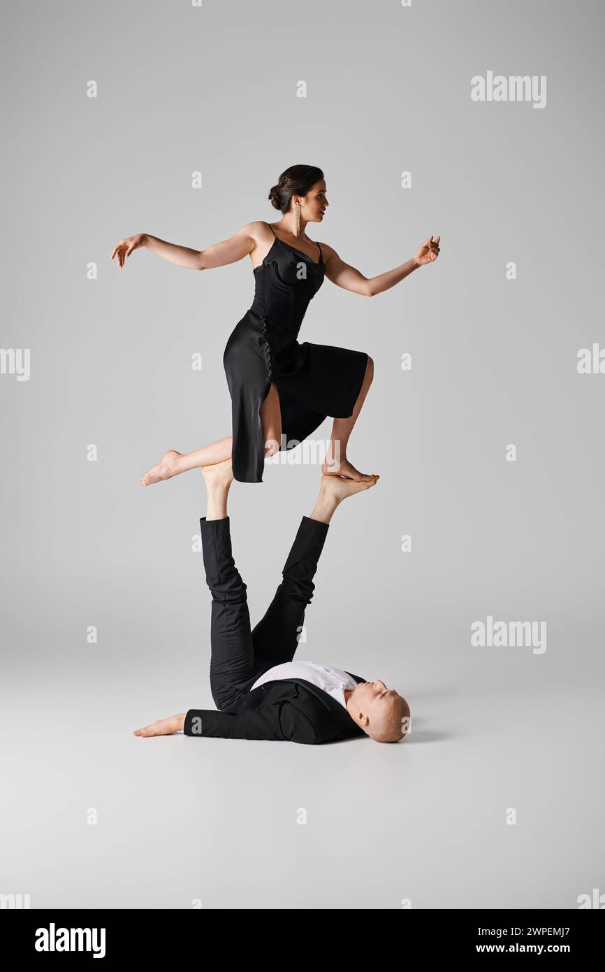Dynamic duo, couple of acrobats performing balance act in a studio ...
