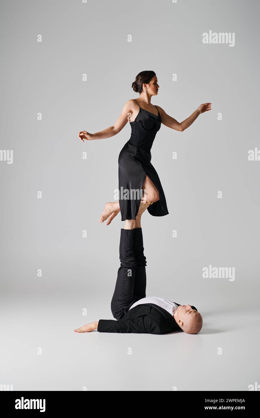 athletic duo, couple of acrobats performing balance act in a studio ...