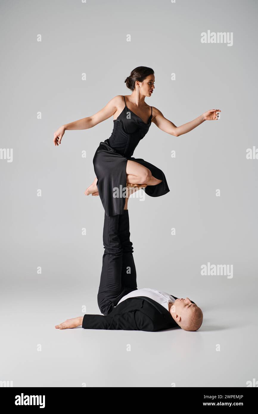 Dynamic duo, couple of acrobats performing balance act in a studio ...