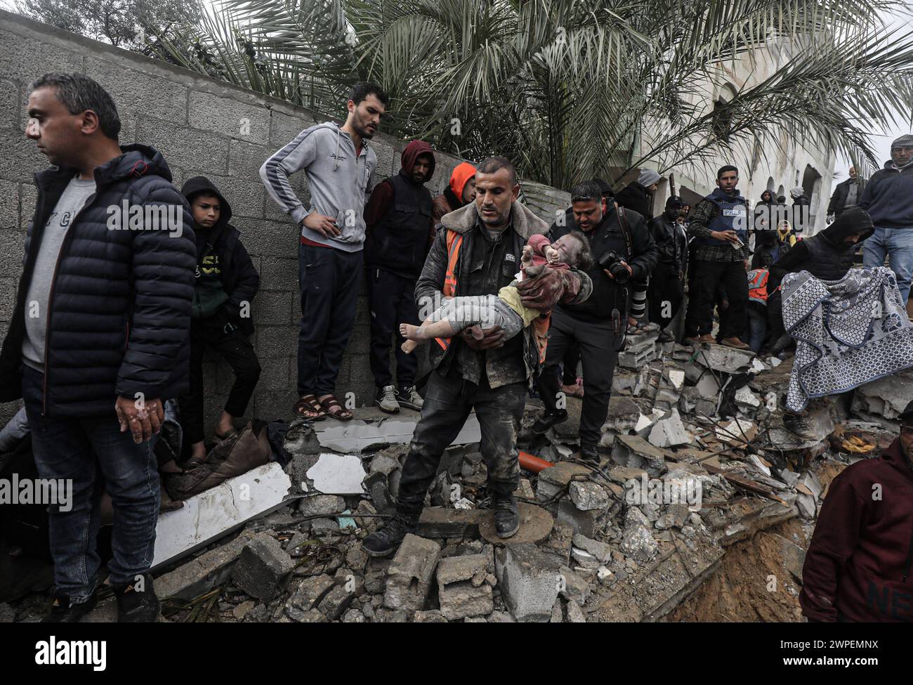 Palestinians recover the body of a child from under the rubble of his ...