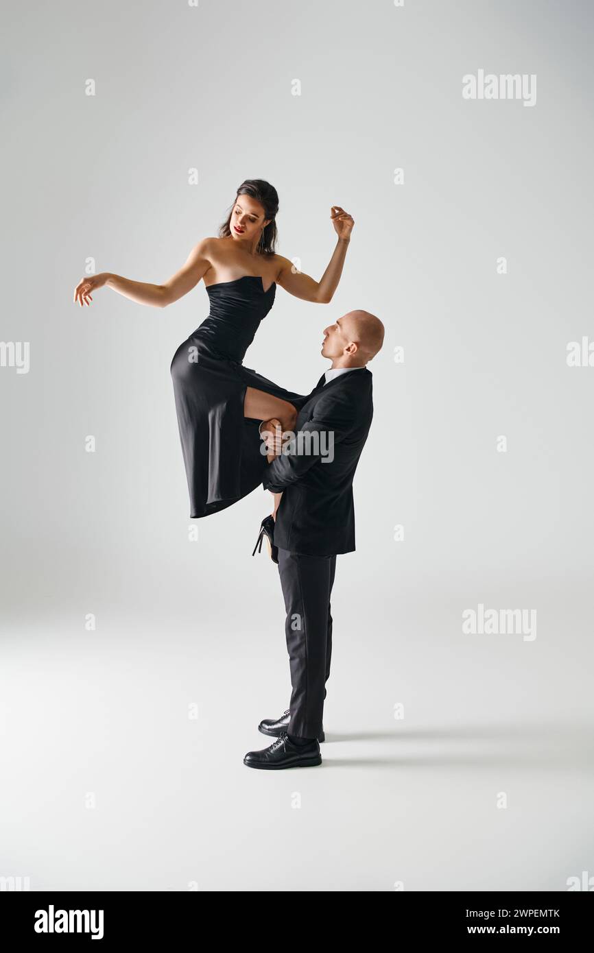 dancer lifting young brunette woman in black dress and high heels ...