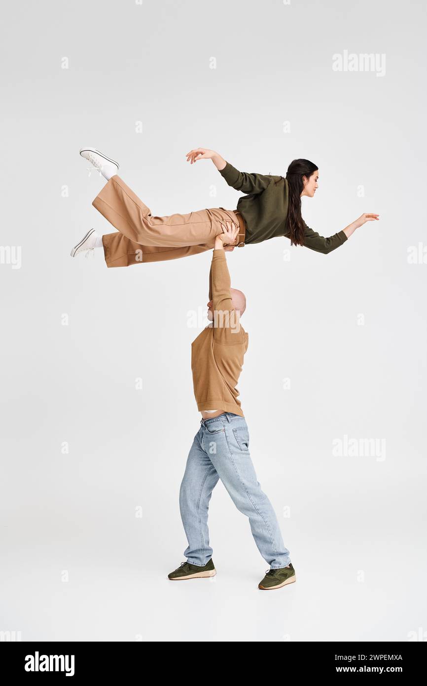 artistic acrobat duo with man lifting and supporting young woman in ...