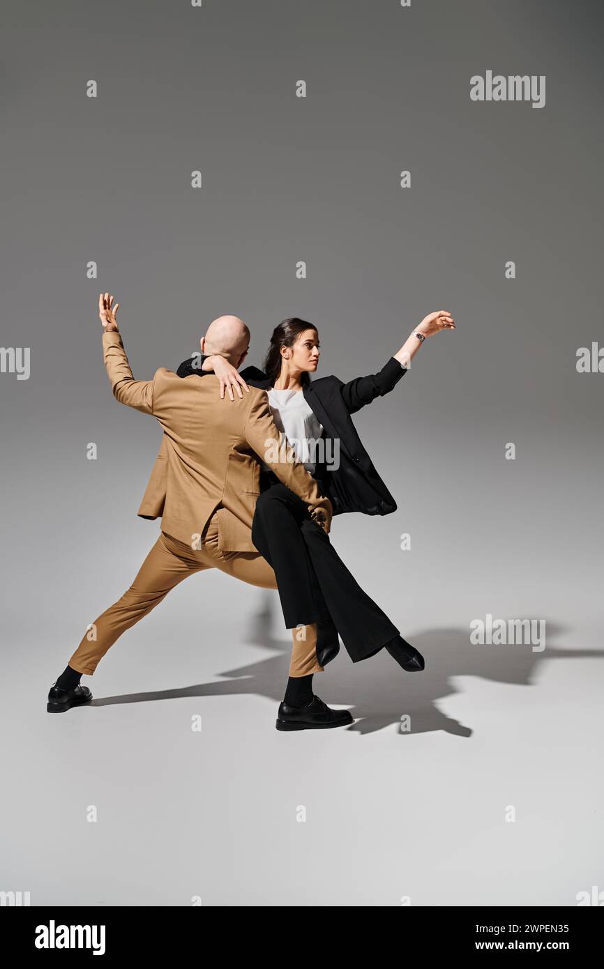 Business couple in suits perform a dynamic dance move in the studio ...