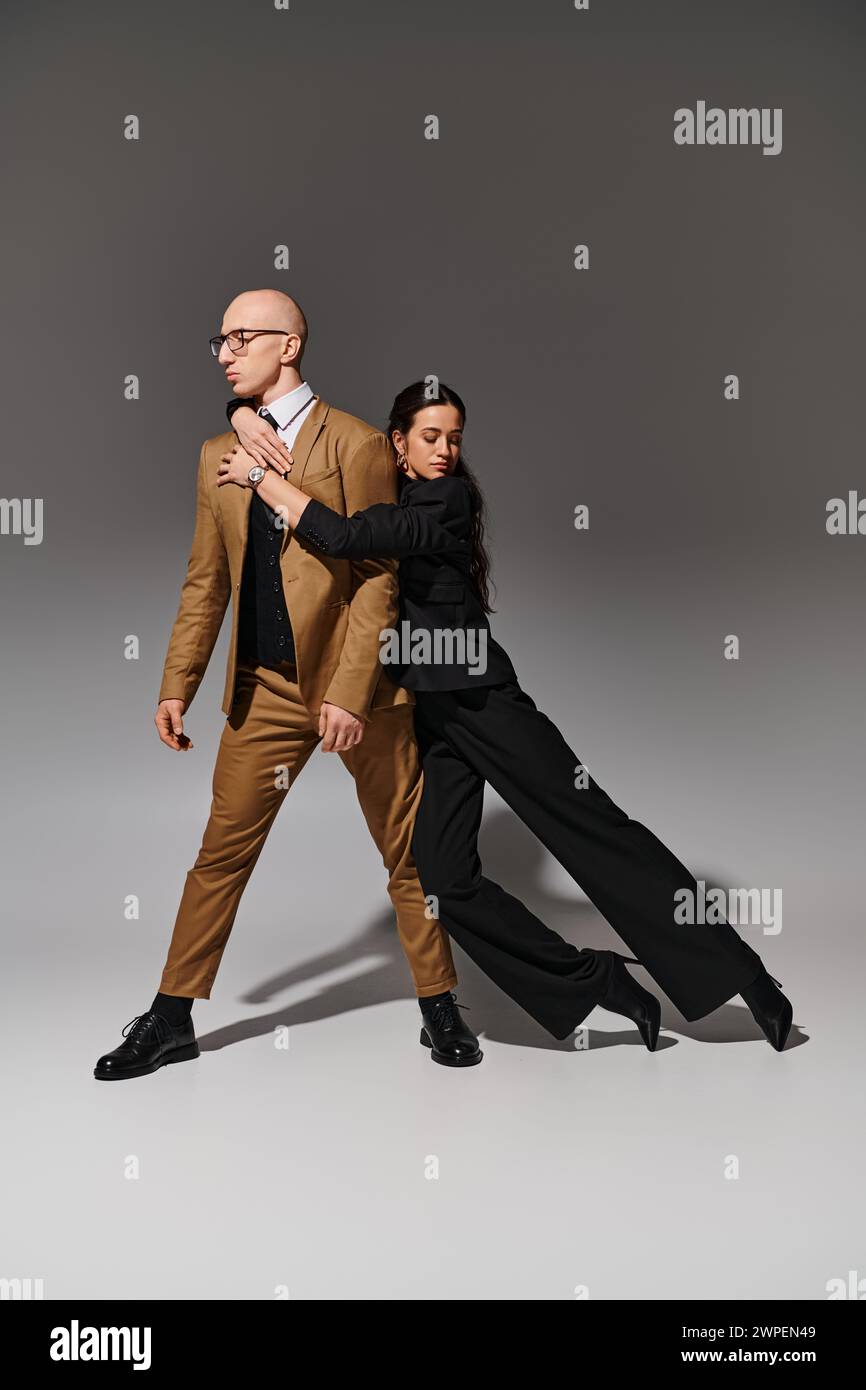 Stylish couple in business attire performing a dance step in studio on ...