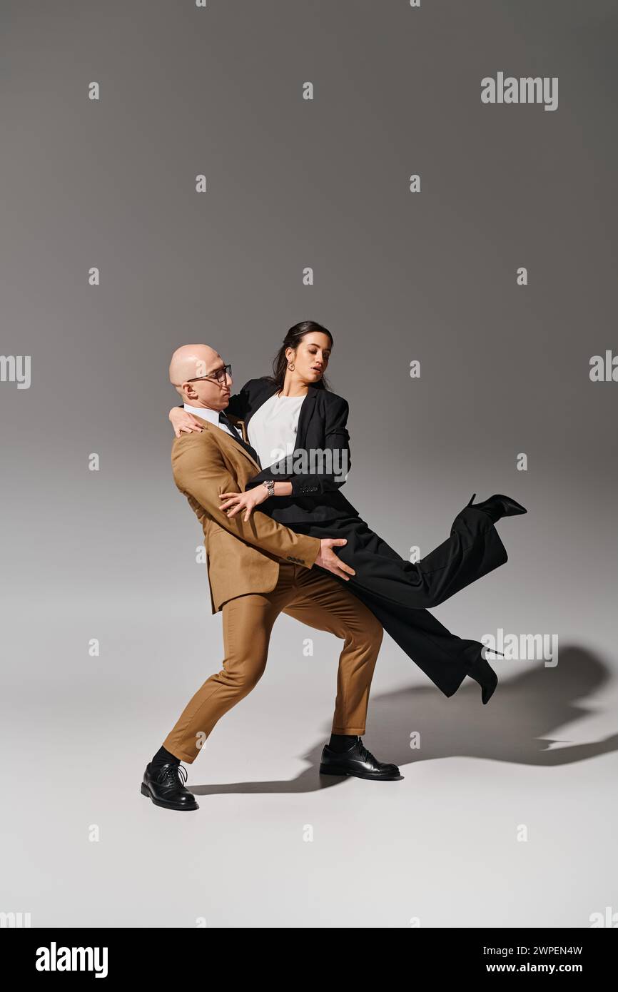 Business couple in stylish suits in creative dancing pose, man ...
