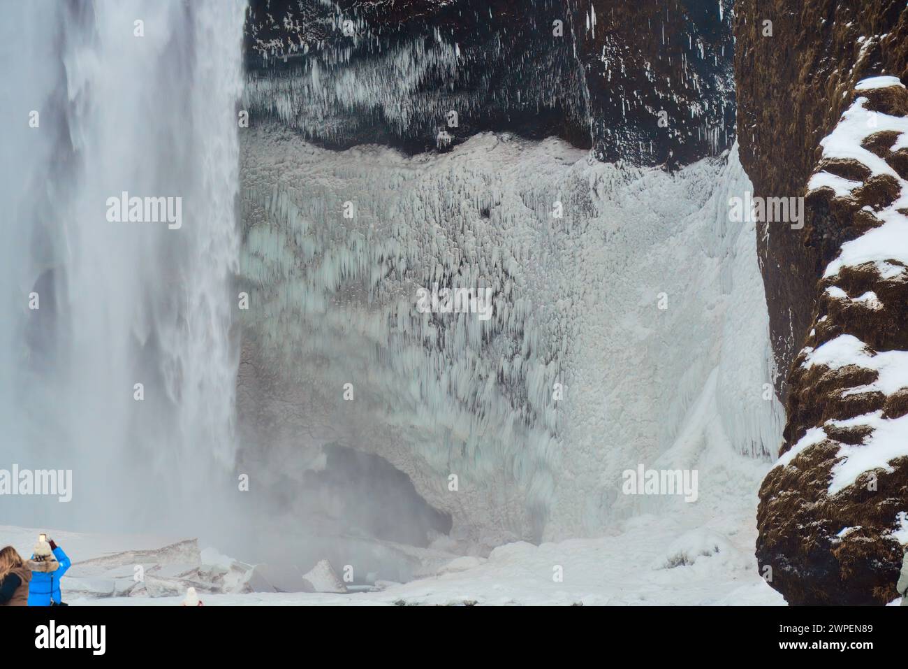 Frozen waterfall with icy surface and snow-covered rocks, showcasing ...