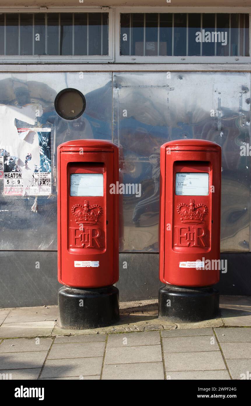 Two red post boxes on pavement, ER 11 and crown, with metallic wall ...