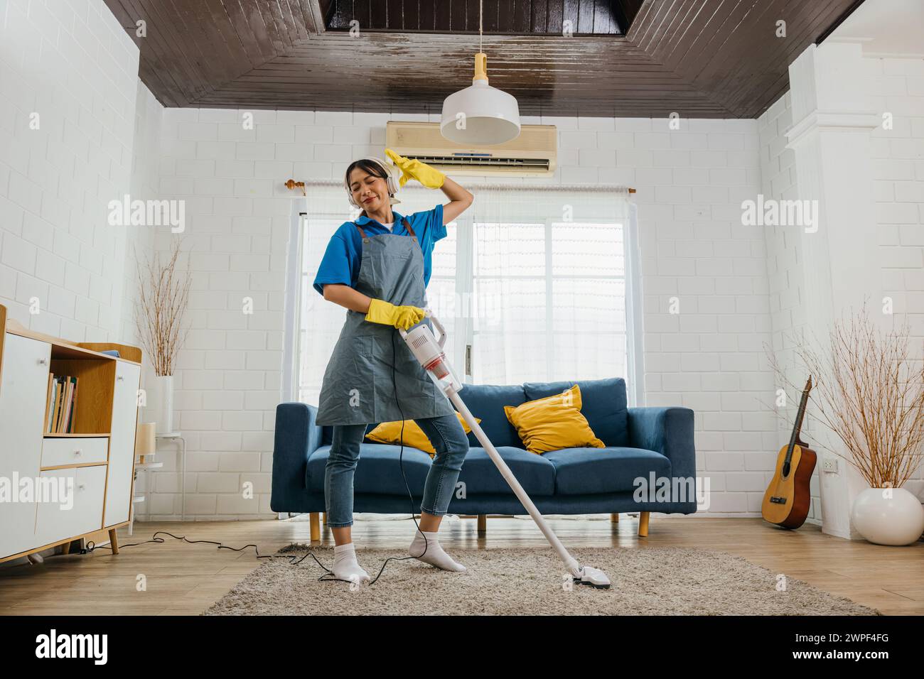 Happy maid's cleanup melody, Asian woman uses mop as mic singing ...