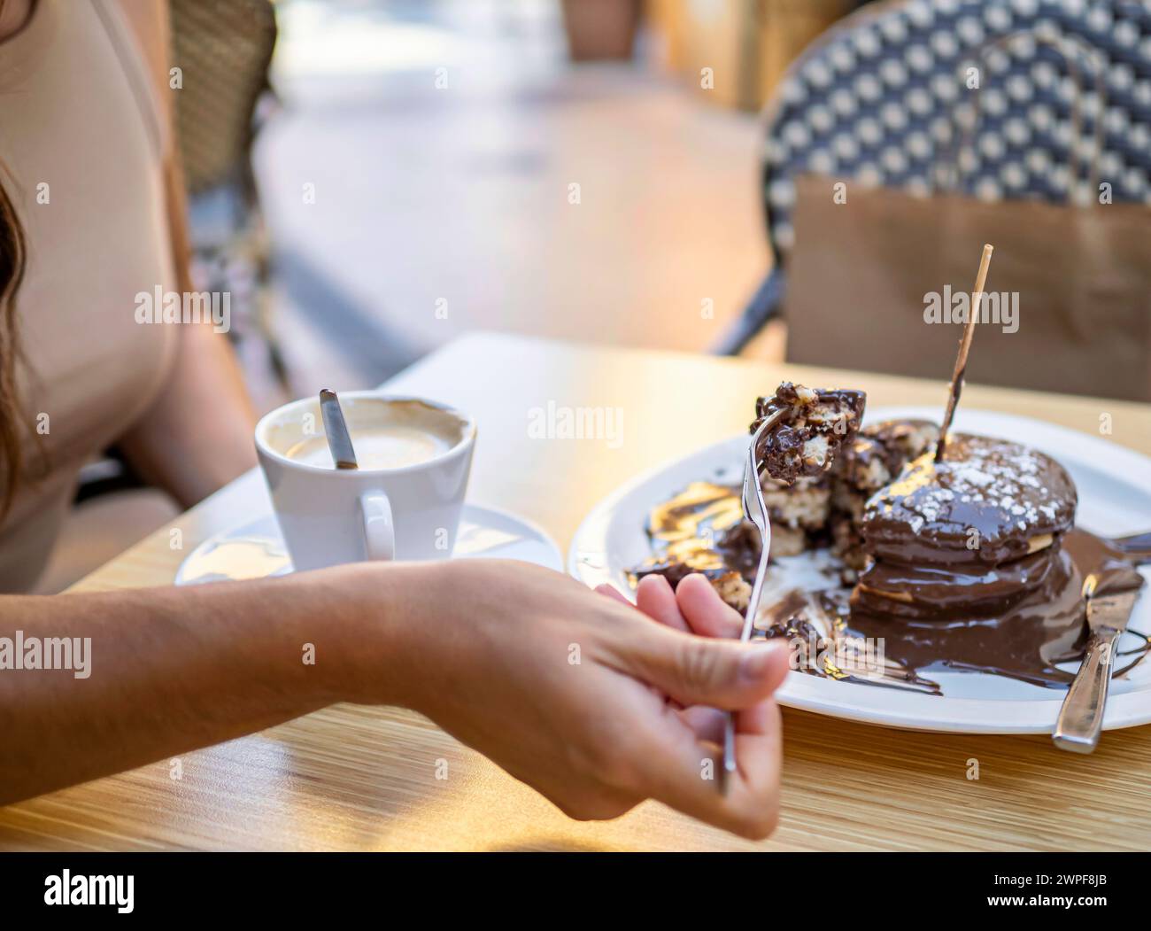 Caucasian woman having a pancake with chocolate on the street sitting ...