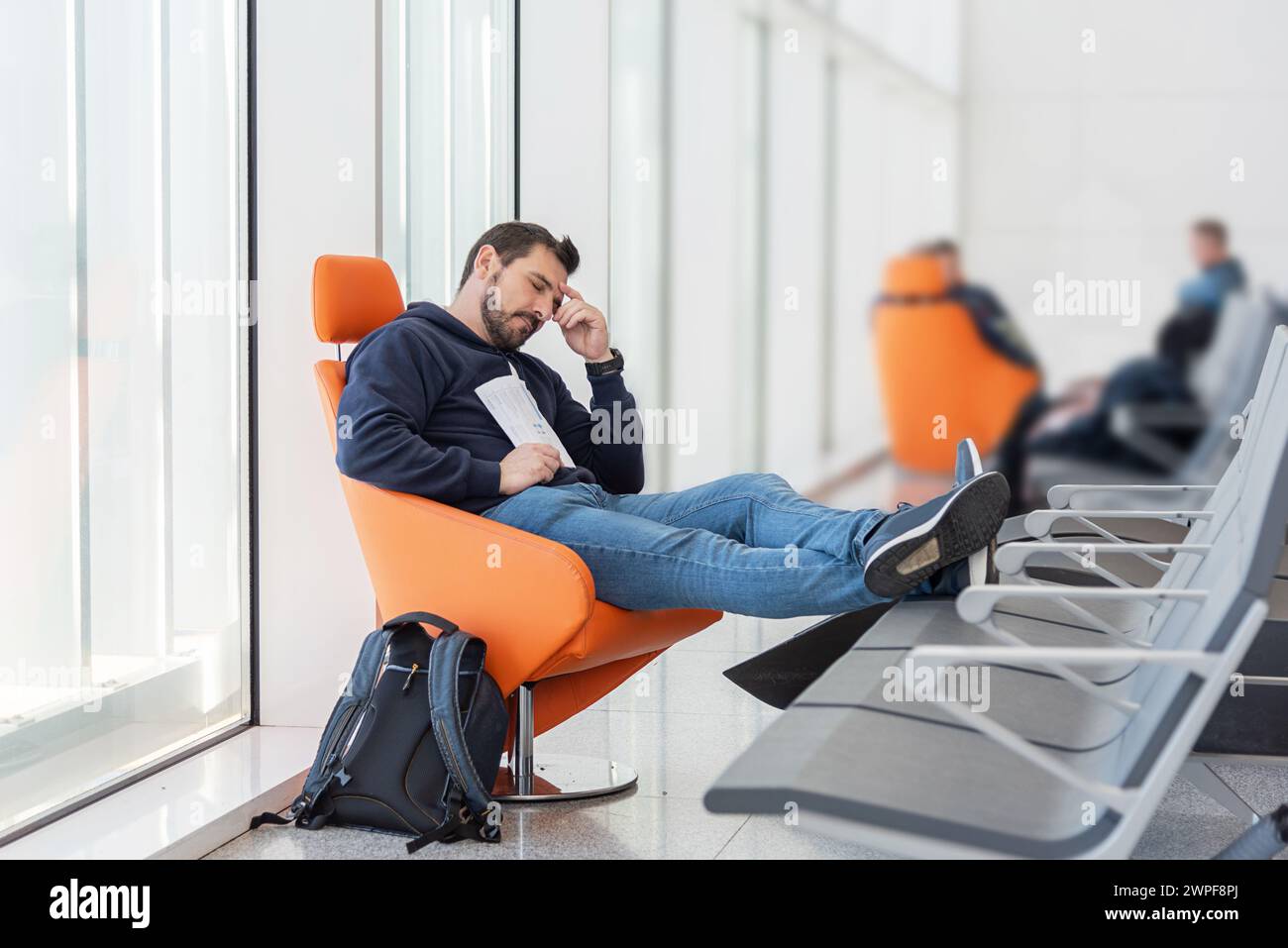Man asleep in a waiting room. Tired of waiting for train, plane, doctor ...