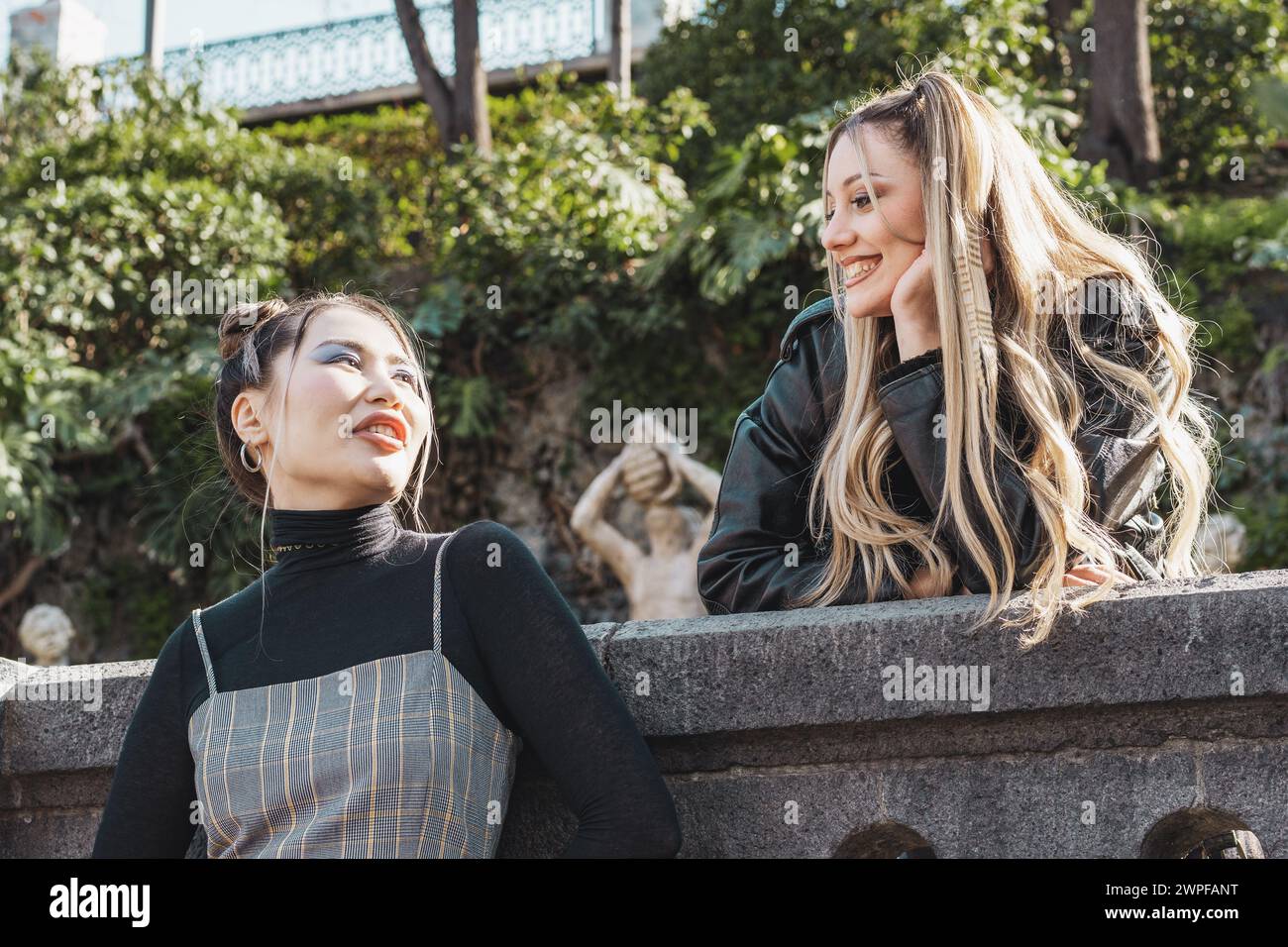 Two friends share laughter - Casual conversation in a sunny park ...