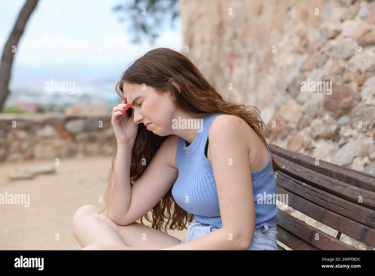 Alone and sad woman sitting on a bench Stock Photo - Alamy