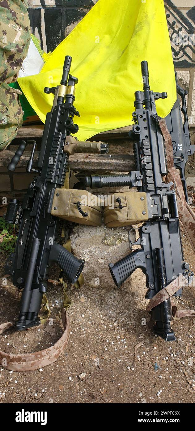 two machine guns against the background of a yellow flag and an old ...