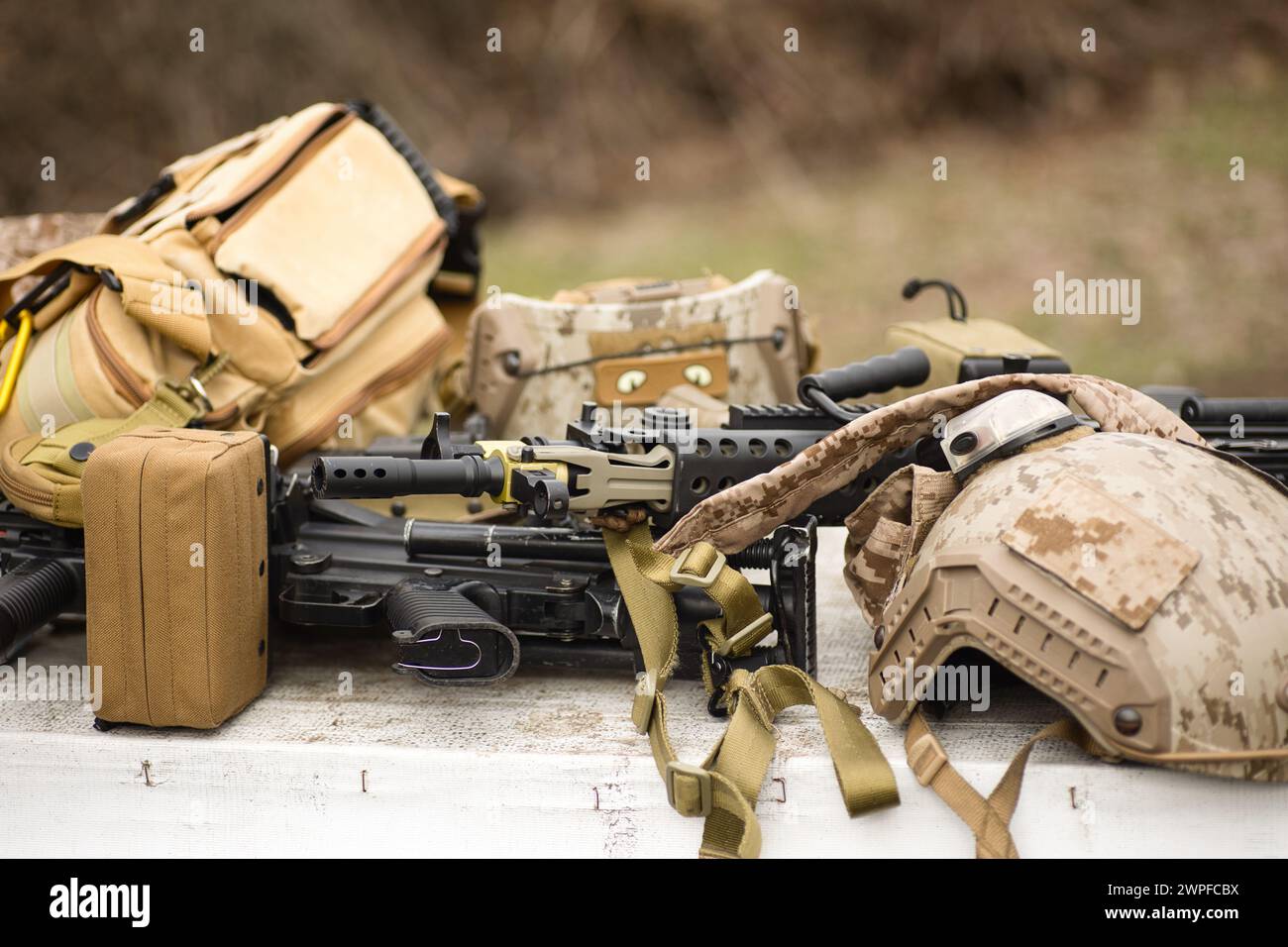 airsoft replica weapon and top camouflage helmet AOR 1, machine gun on ...