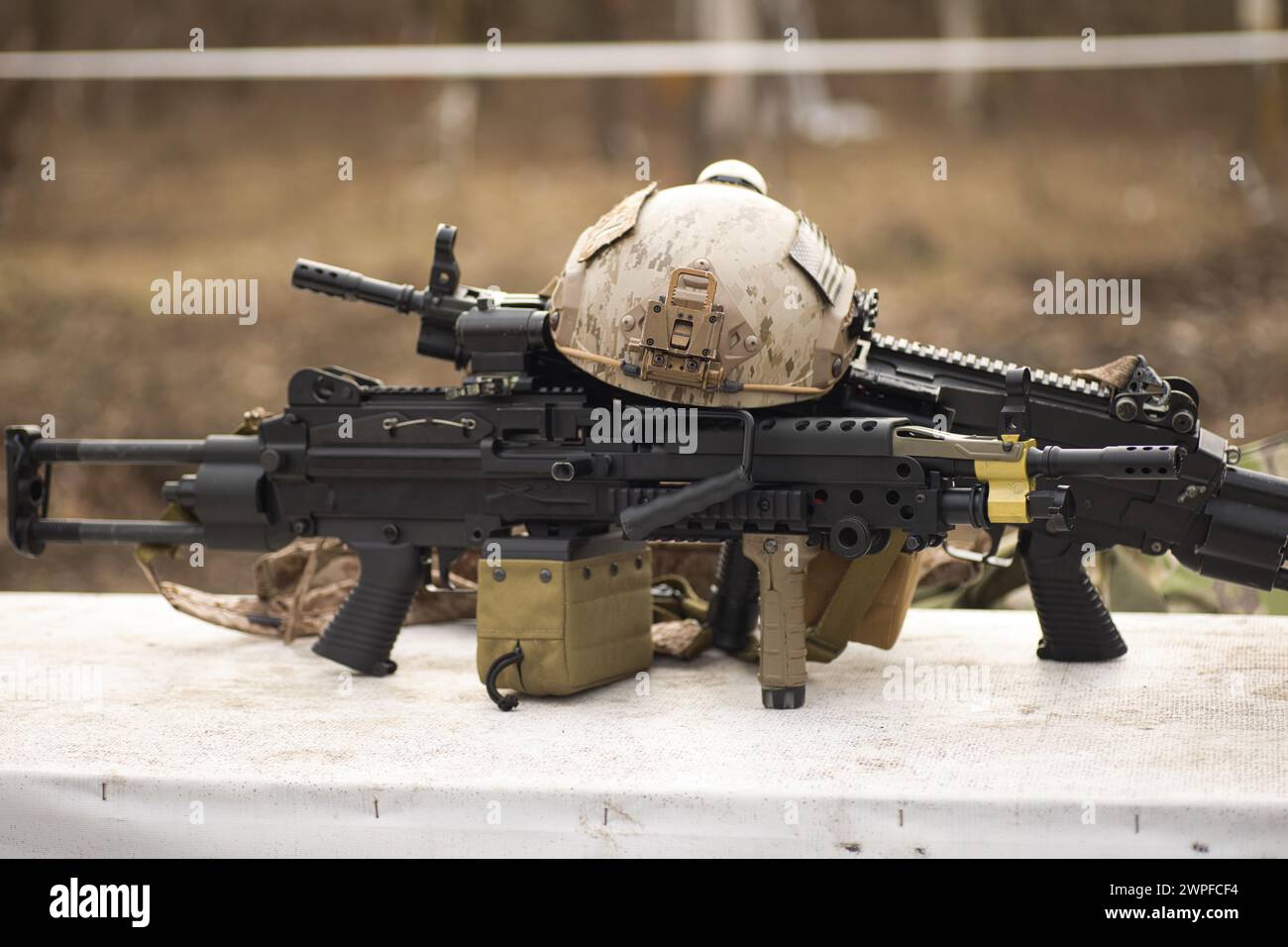 airsoft replica weapon and top camouflage helmet AOR 1, machine gun on ...