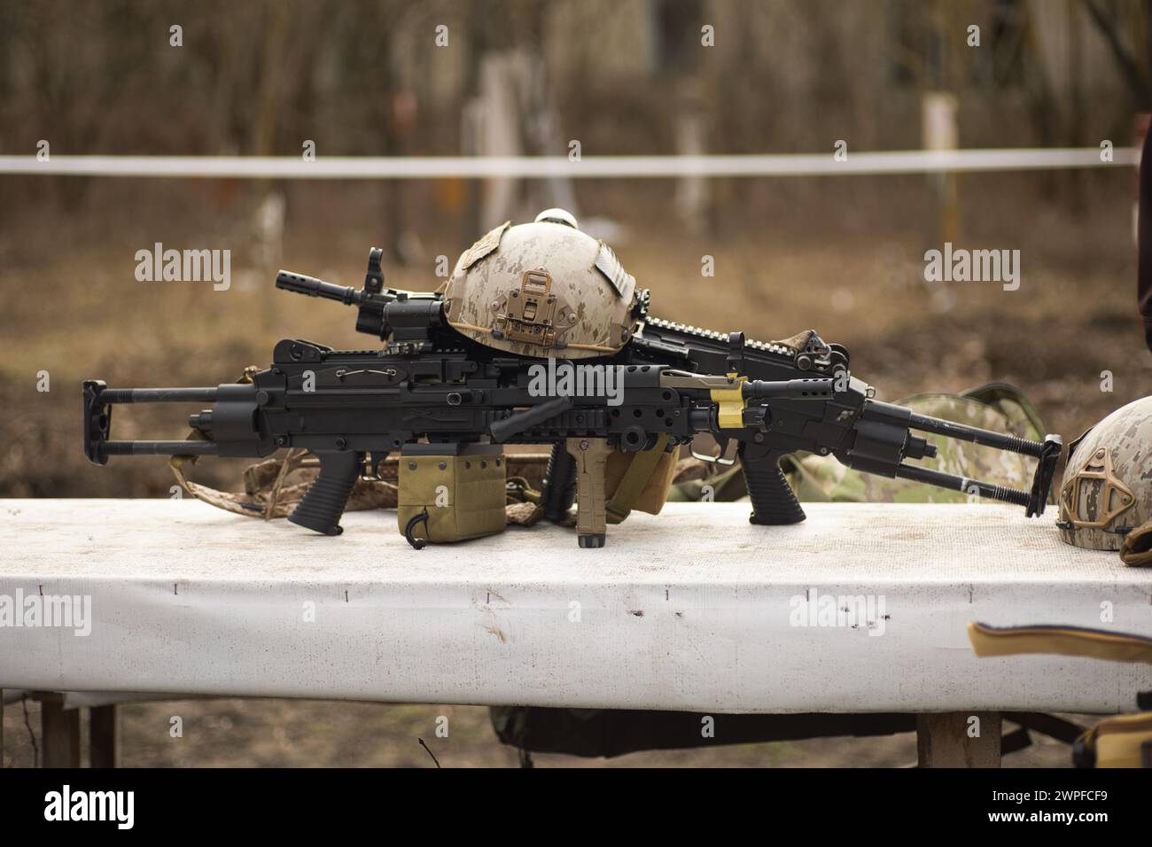 airsoft replica weapon and top camouflage helmet AOR 1, machine gun on ...