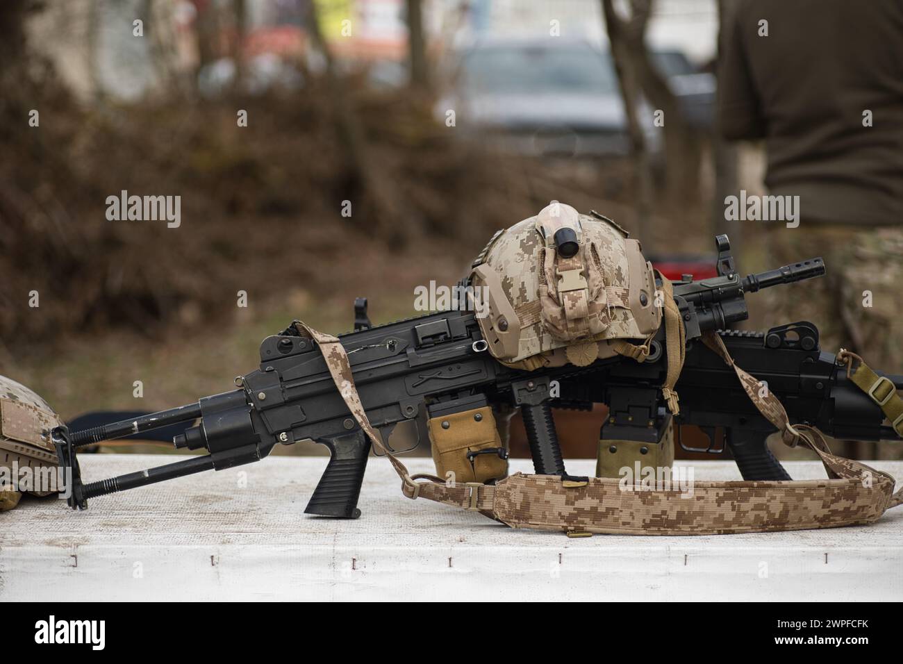 airsoft replica weapon and top camouflage helmet AOR 1, machine gun on ...