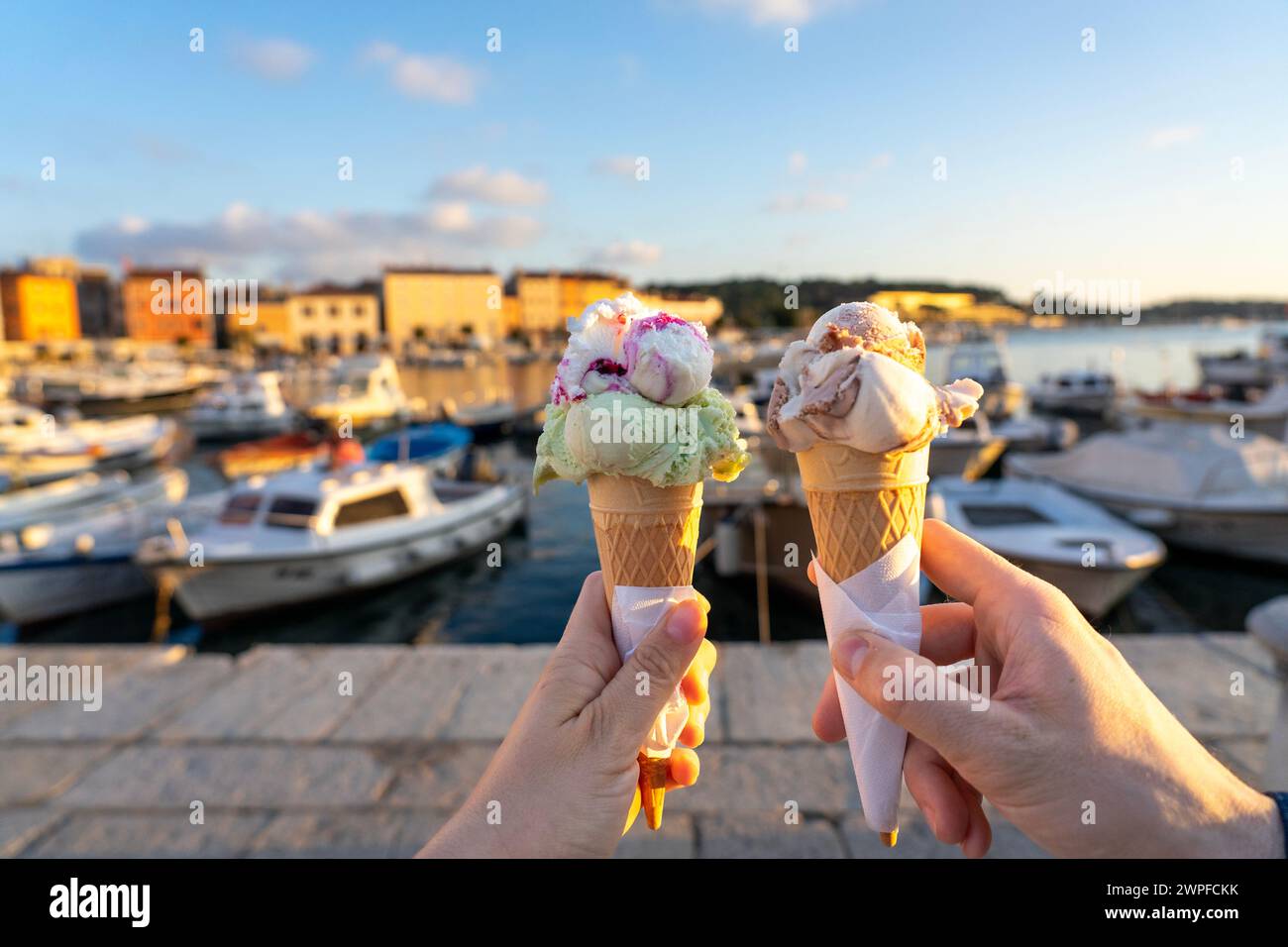 couple eating ice cream in Rovinj harbor with sunlight Stock Photo - Alamy