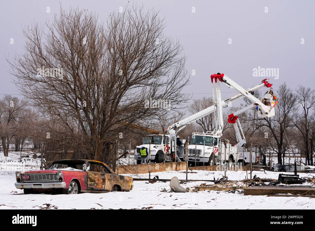 FILE - Utility workers from Xcel Energy labor on power lines near a ...