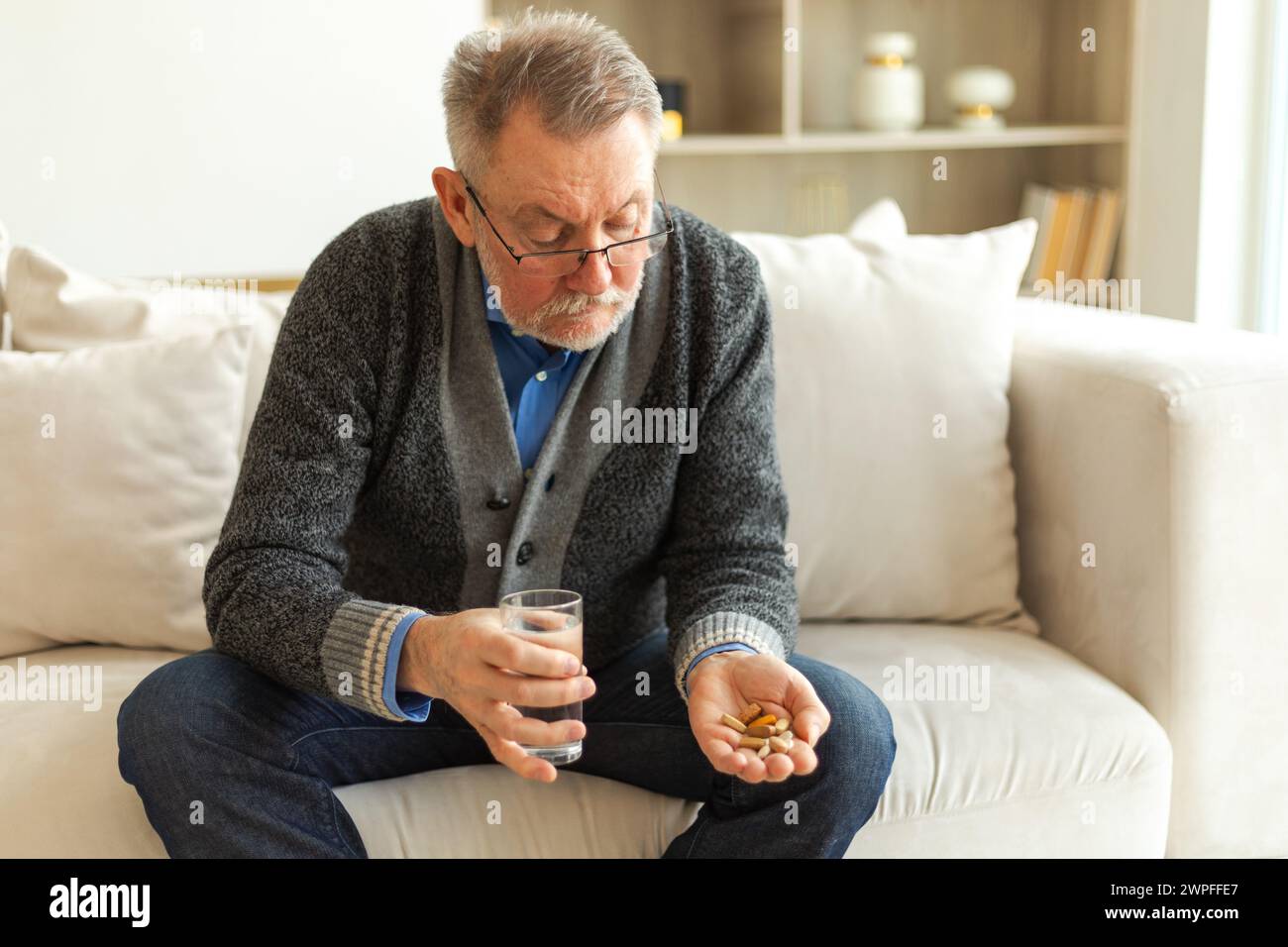 Middle aged senior man holding medical pill and glass of water. Mature ...