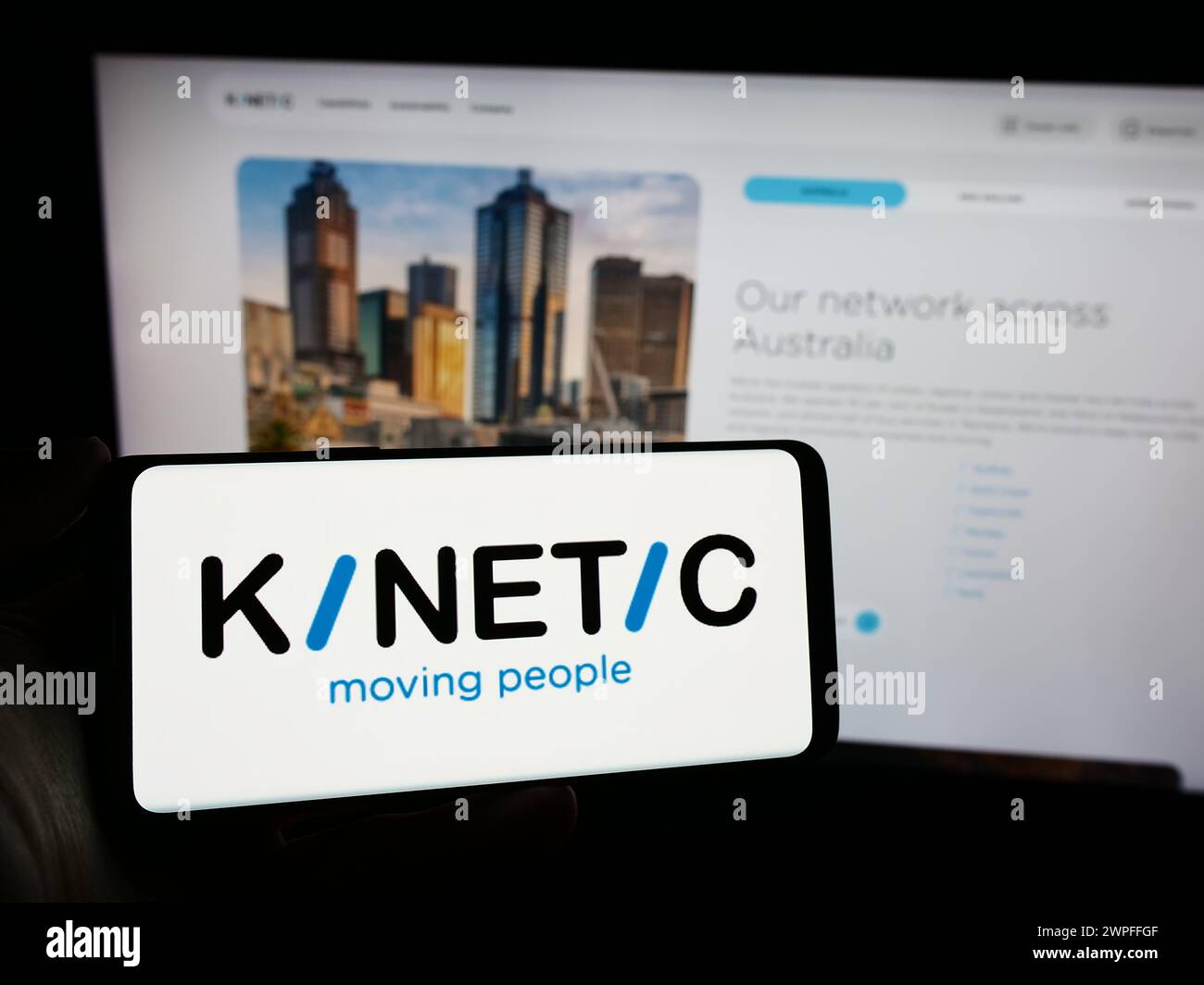 Person holding mobile phone with logo of Australian mobility company ...