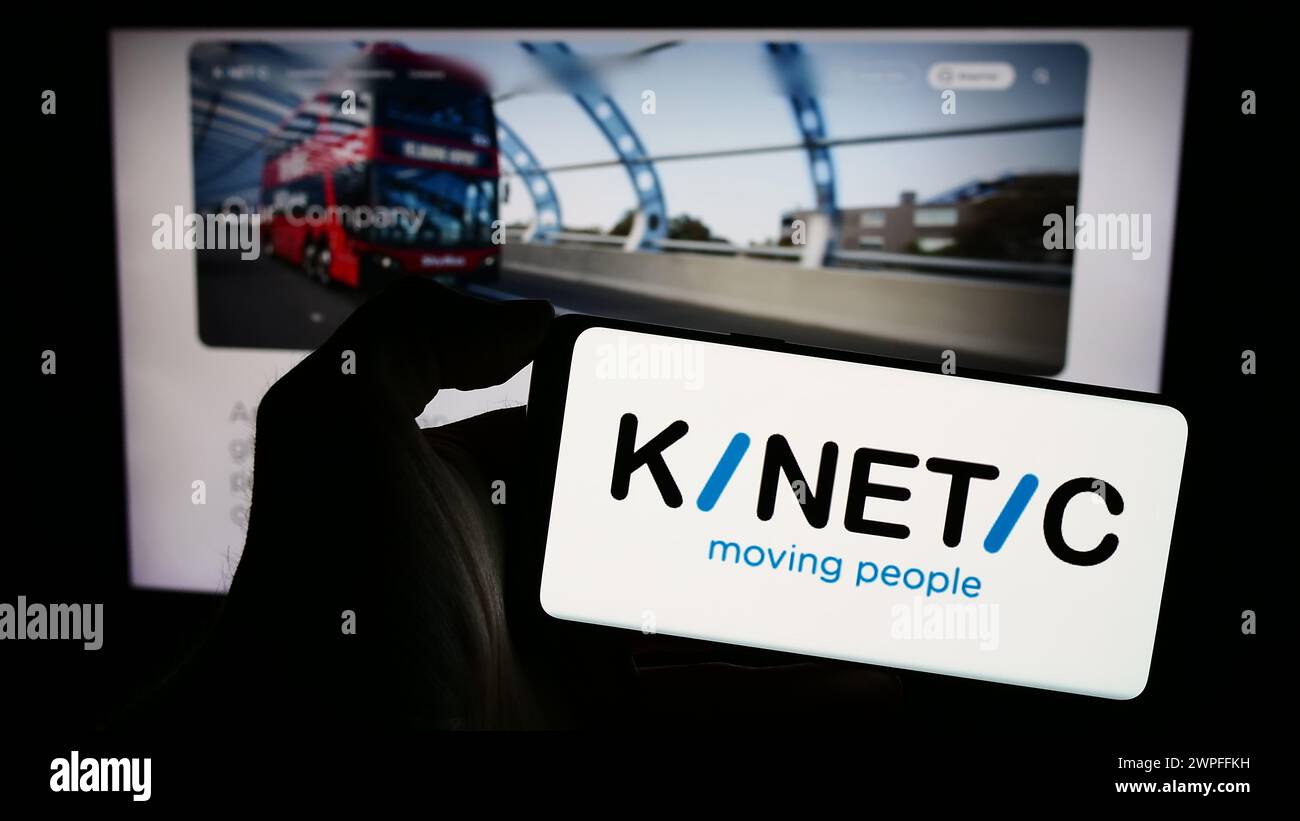 Person holding cellphone with logo of Australian mobility company Kinetic Group in front of ...