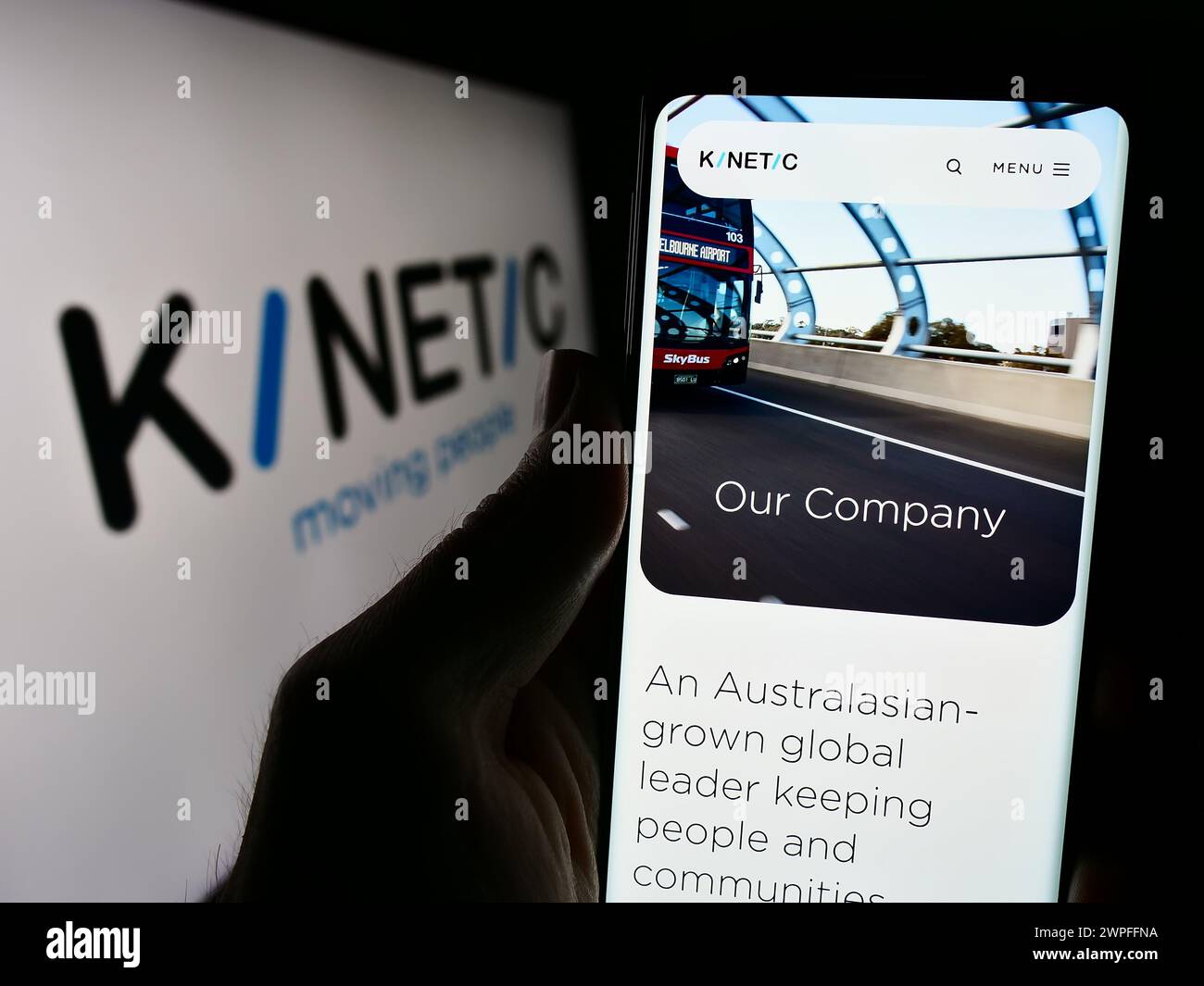 Person holding cellphone with webpage of Australian mobility company ...