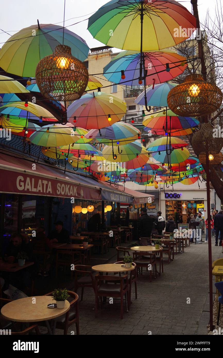 An alleyway covered in colourful umbrella's next to a cafe in Istanbul ...