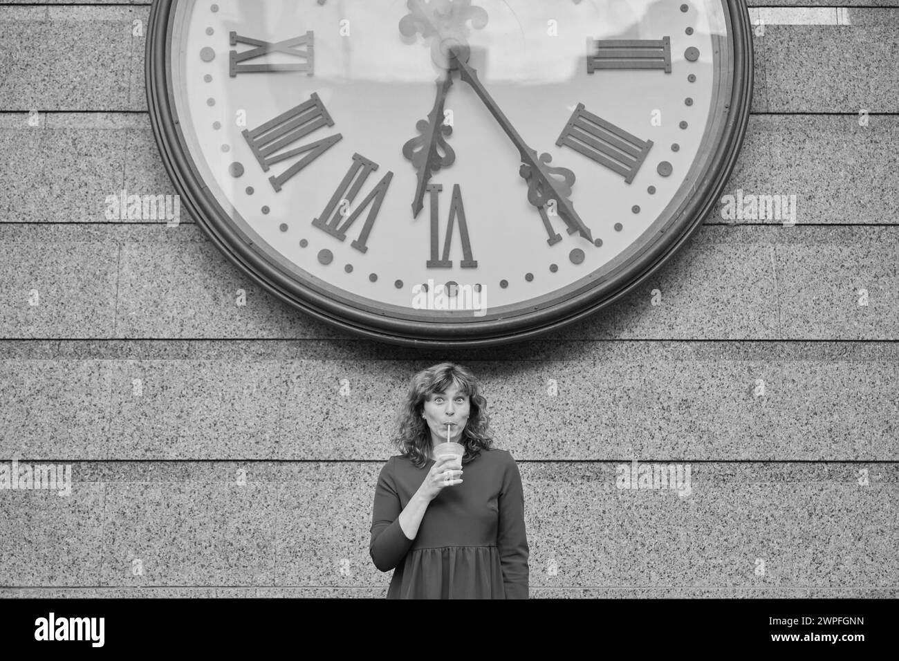 Watch the time concept. woman in dark red dress with cold tea next to ...