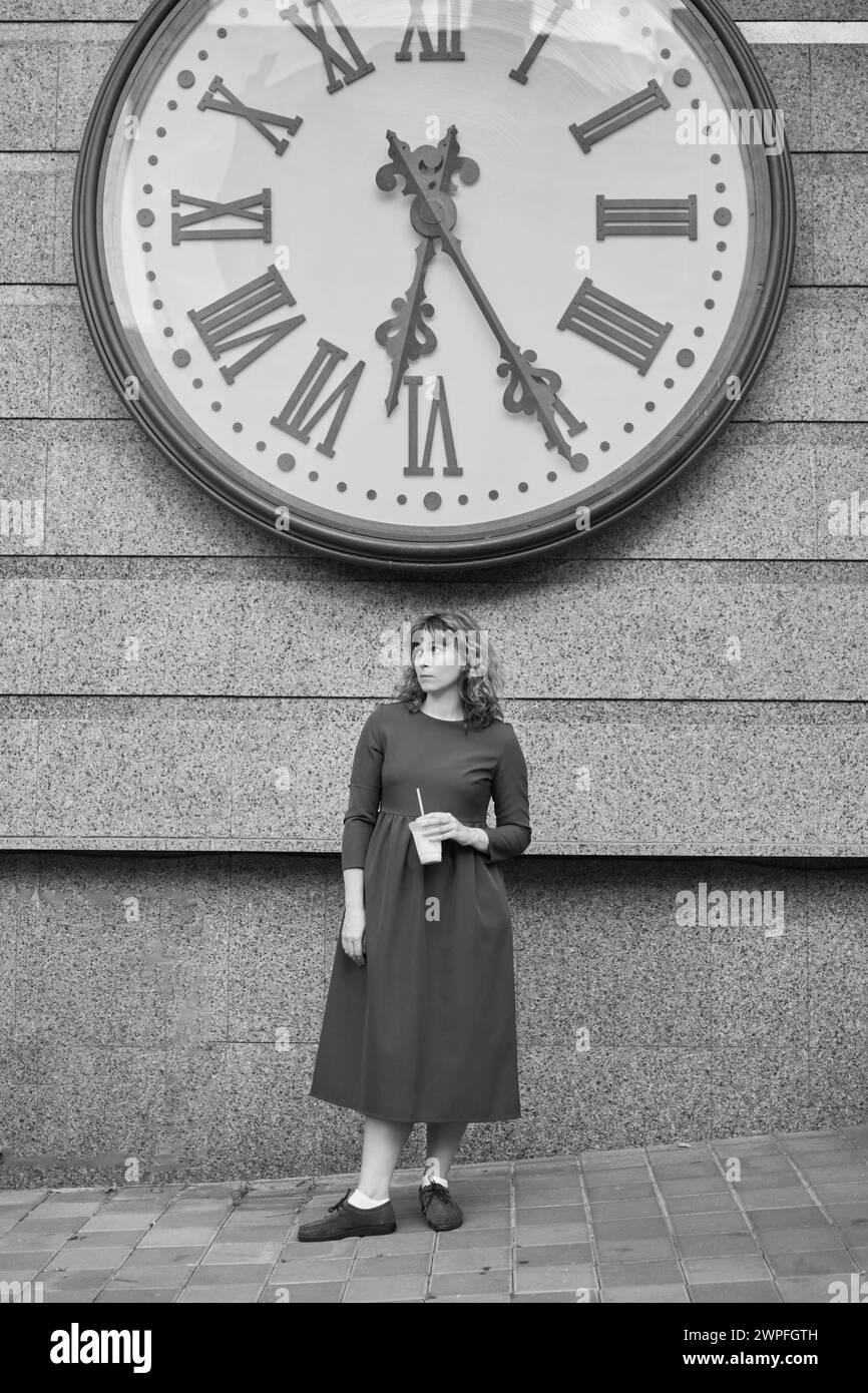 Watch the time concept. woman in dark red dress with cold tea next to ...
